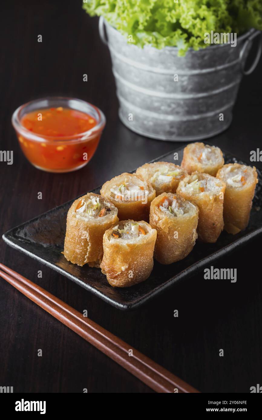 Thai spring rolls with sauce on wooden background Stock Photo - Alamy