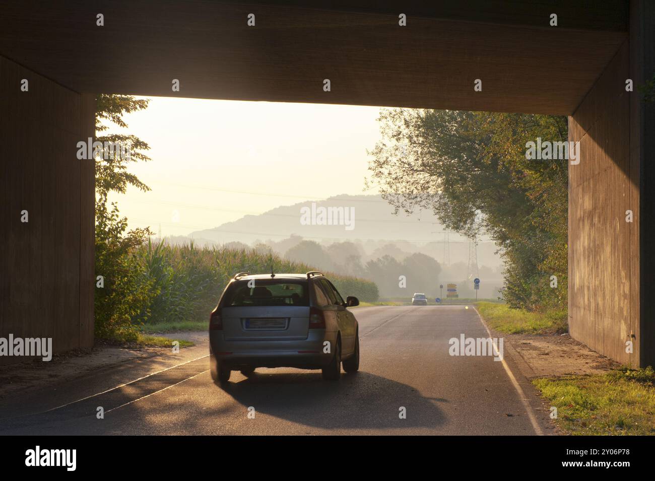Car drives under a bridge in the morning light Stock Photo - Alamy