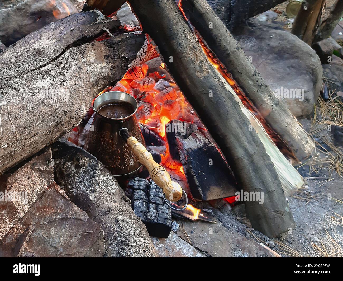 Brew coffee in a Turk on an open fire Stock Photo - Alamy
