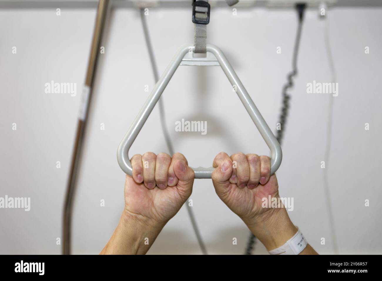 Patient holds on to a triangle handhold, symbol image hospital, illness ...
