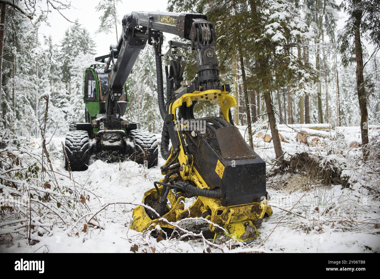 Hydraulic excavator in forest. Winter snow. Tree falling tree cutting ...
