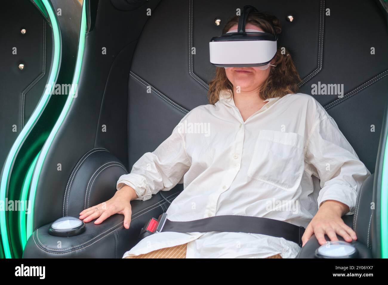 Woman wearing virtual reality headset seated in a futuristic chair ...