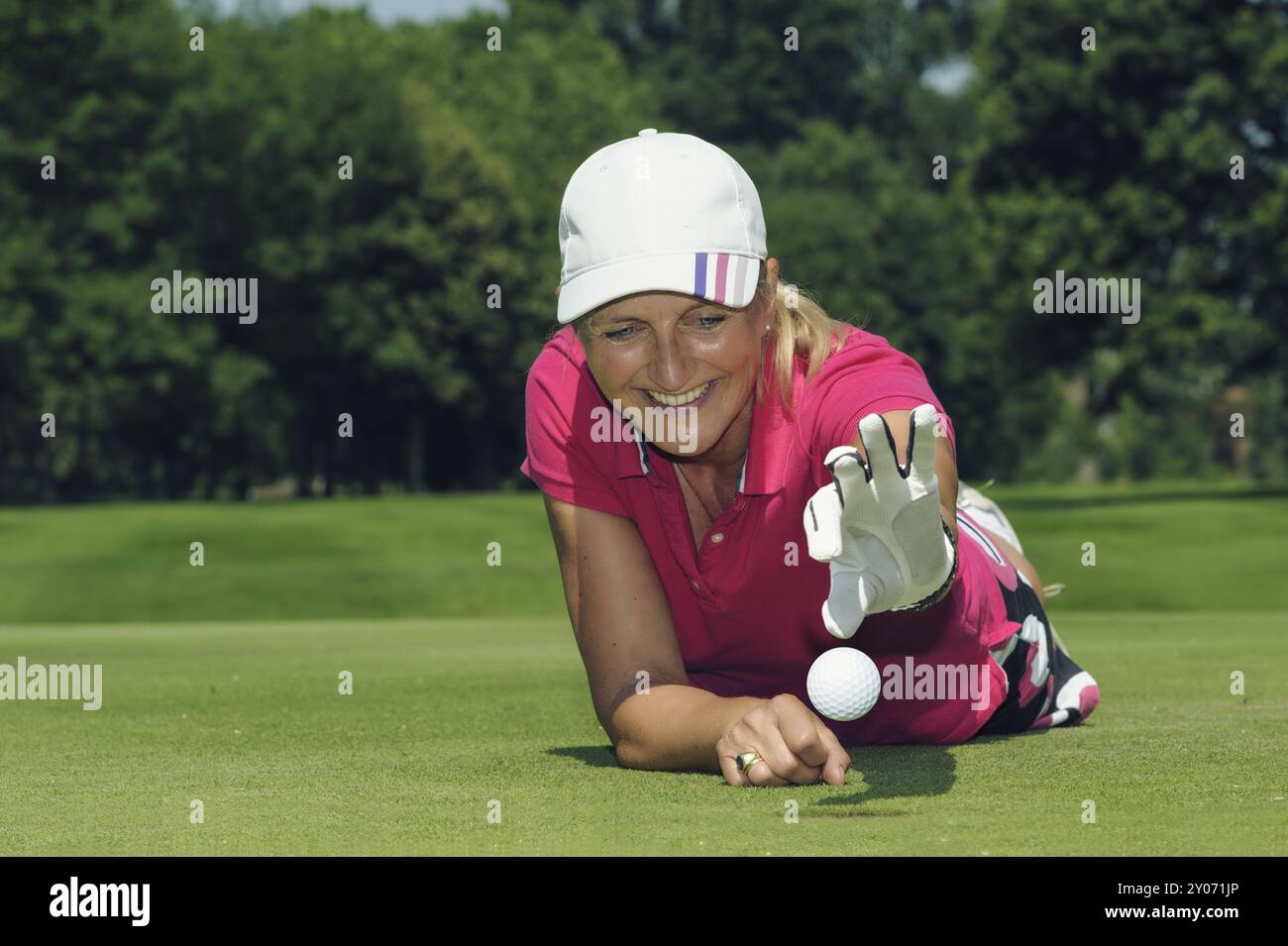 Golfer drops the ball into the hole Stock Photo - Alamy