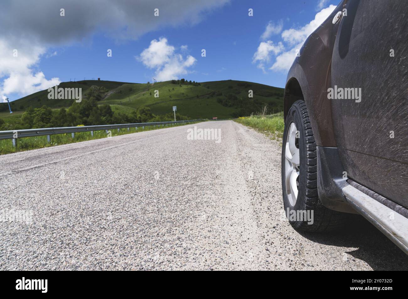 Close-up of a SUV wheel on an asphalt road outside the city against the ...