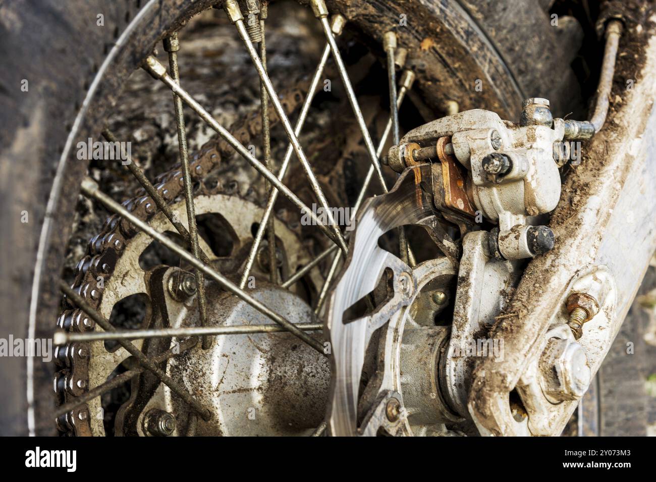 A close-up of the disc rear brakes of an off-road enduro motorcycle ...