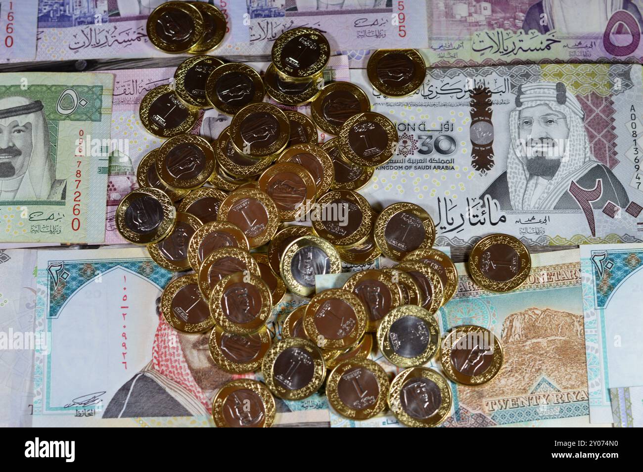 Coins of one Saudi Arabian riyal on Saudi Arabia money banknotes of ...