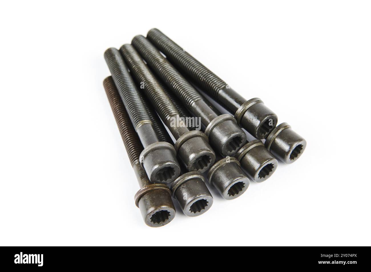 A set of new cylinder head bolts in oil on a white isolated background ...