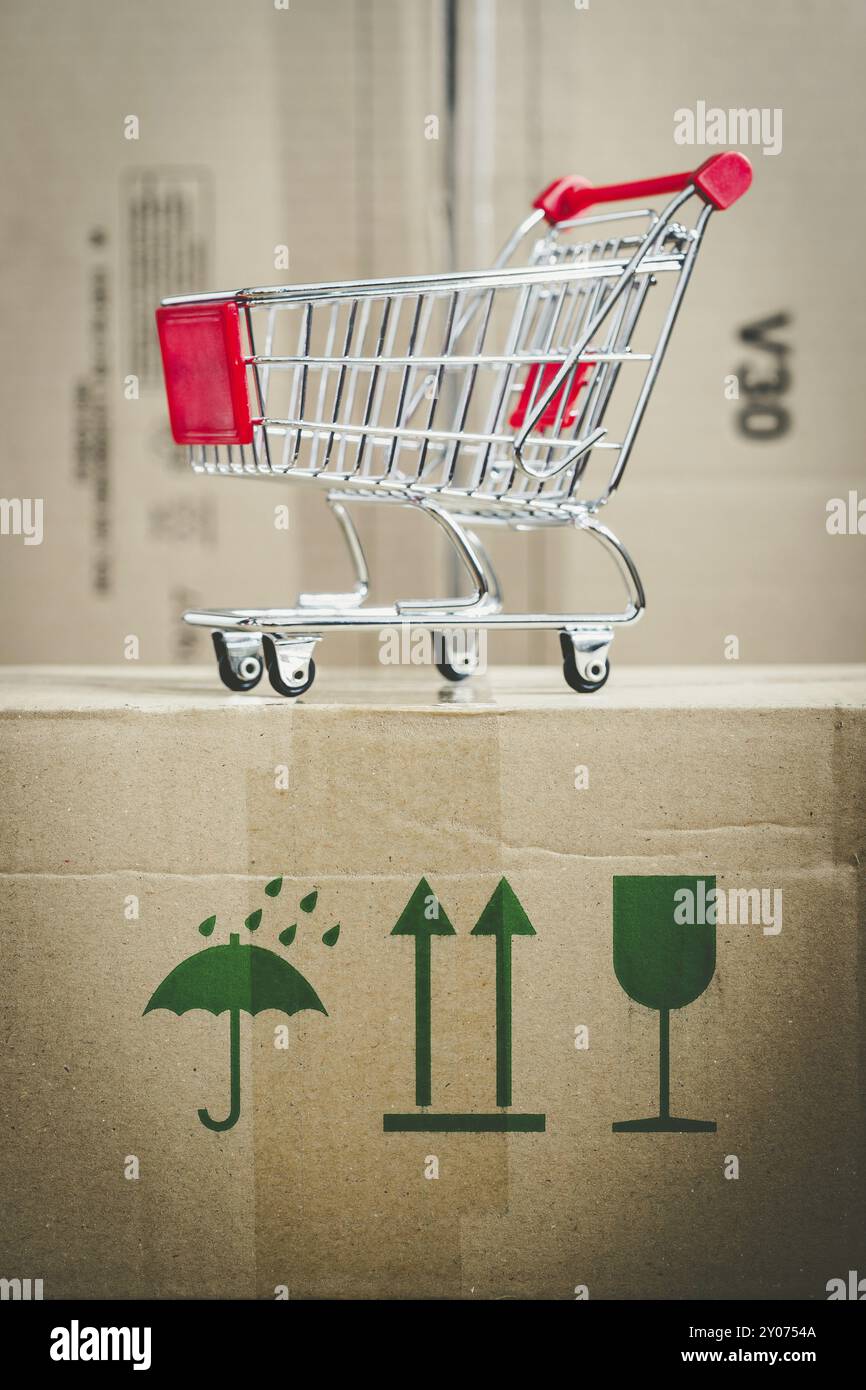 Online-Shopping and parcel service concept: Miniature shopping cart and ...