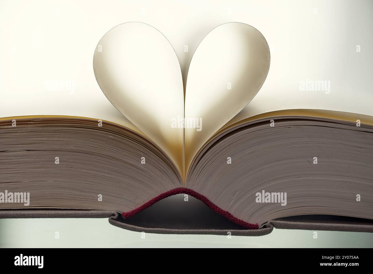 Open book with heart-shaped curved inside pages Stock Photo - Alamy