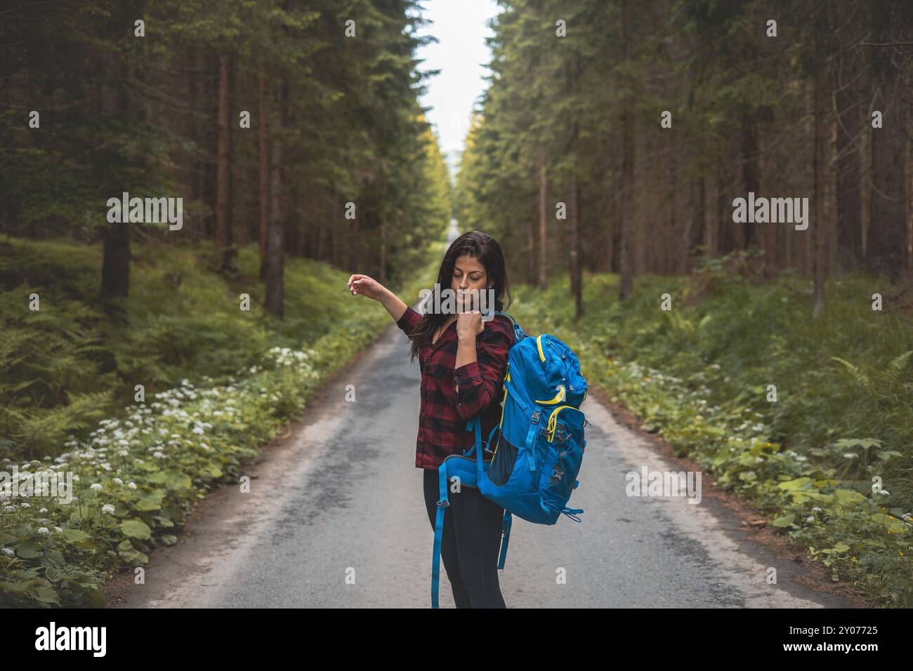 View of a woman with a blue backpack walking barefoot down a peaceful ...