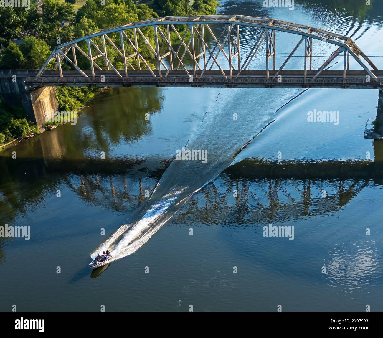 A bass boat on the Allegheny River passing under the Tidioute Bridge in ...