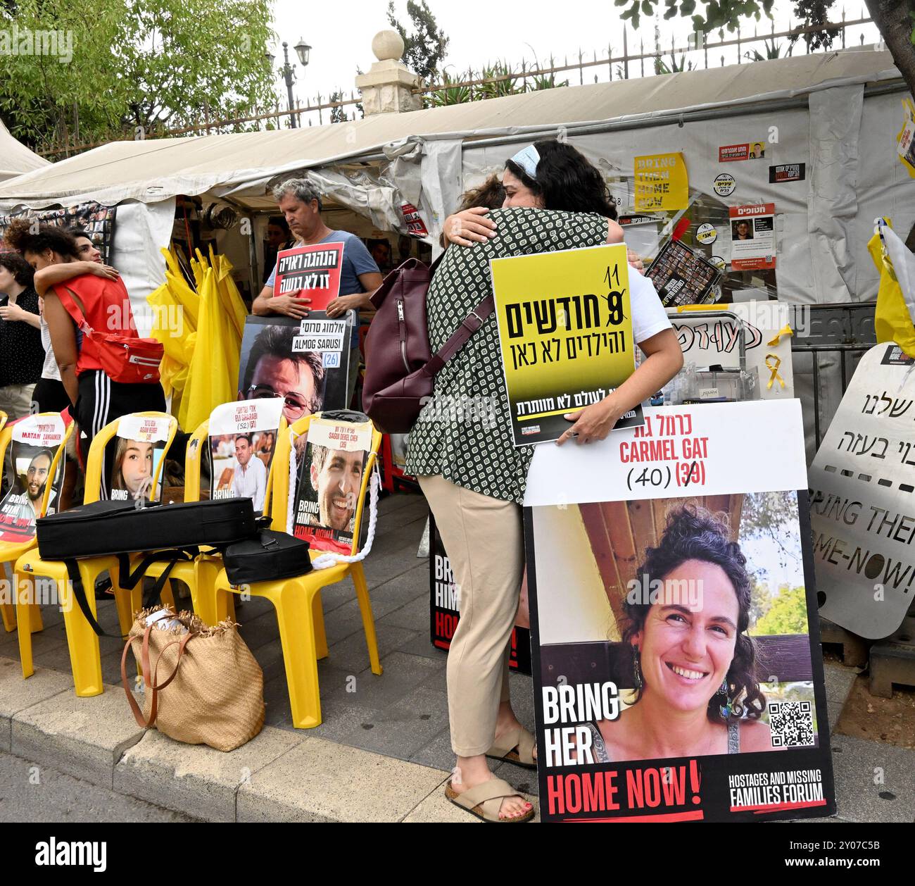 Women embrace while holding a poster of Carmel Gat, 40, one of Israeli ...