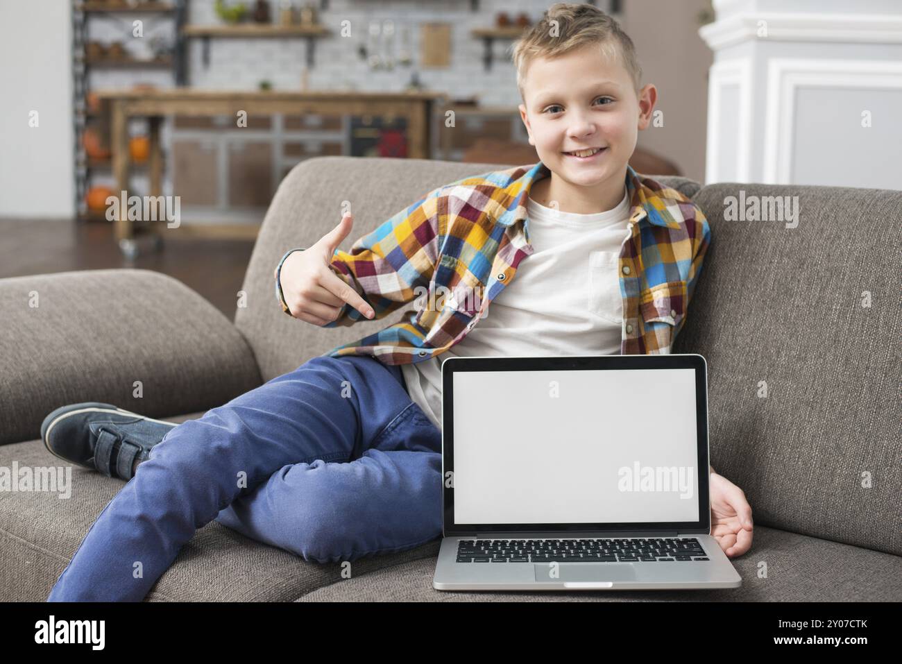 Boy couch showing laptop screen Stock Photo - Alamy
