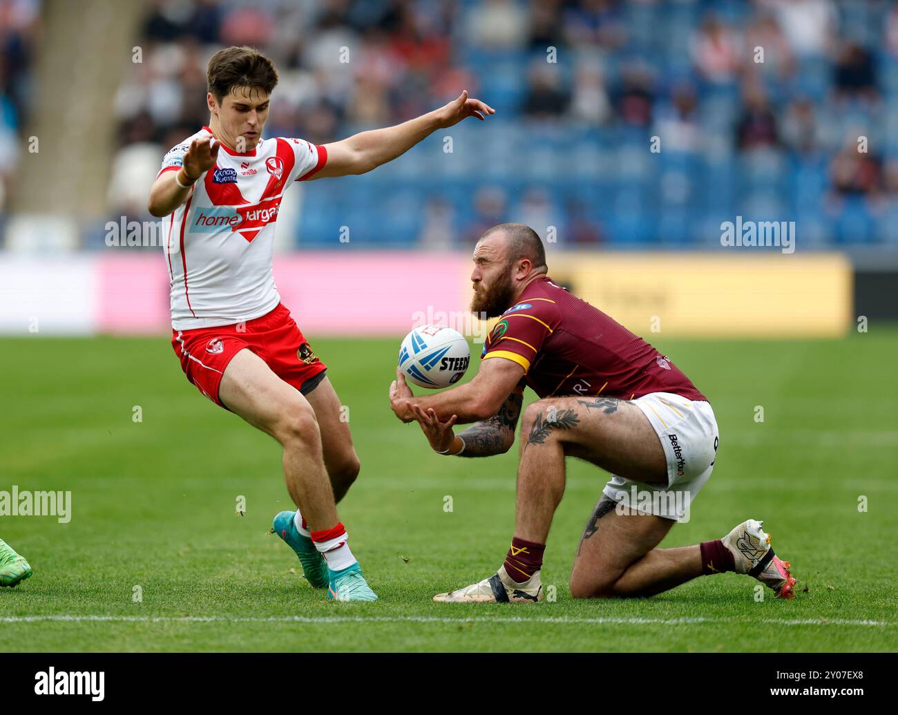 Huddersfield Giants' Jake Bibby (right) catches the ball under pressure ...