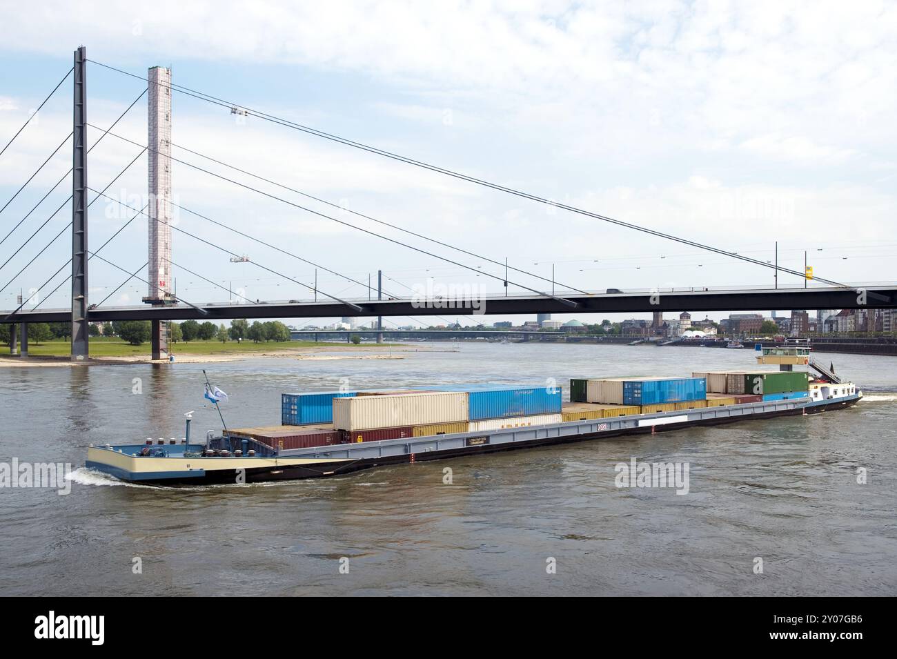 Barge with containers passes Duesseldorf under the Rhine knee bridge ...