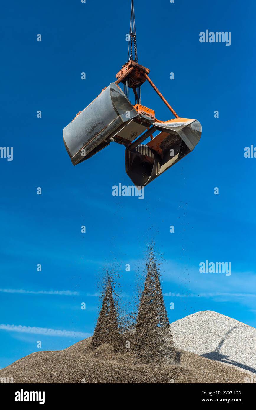 Grab crane fills sand on a hill Stock Photo - Alamy