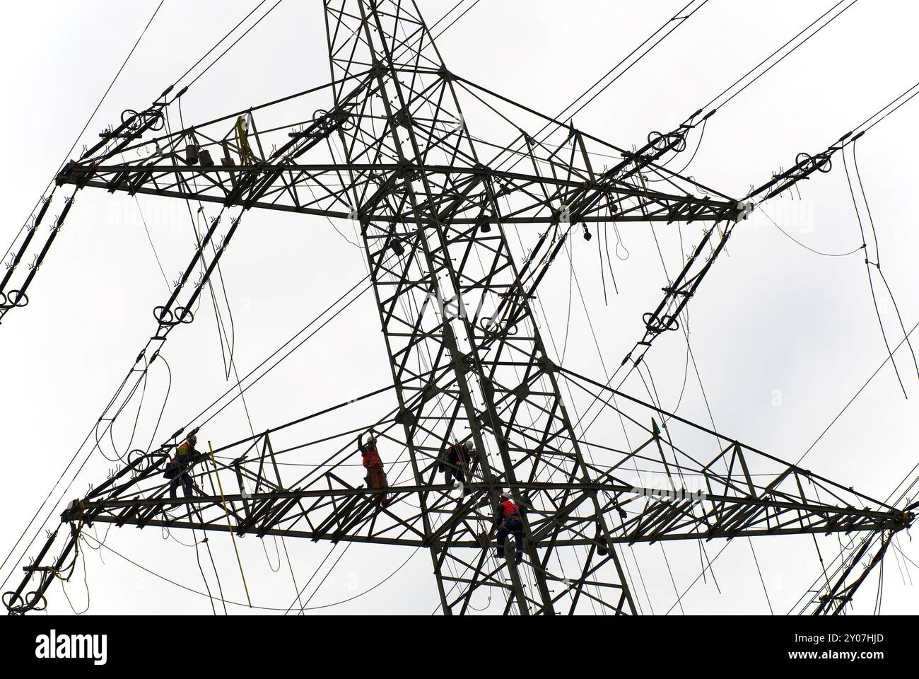 High-voltage pylon with fitters Stock Photo - Alamy