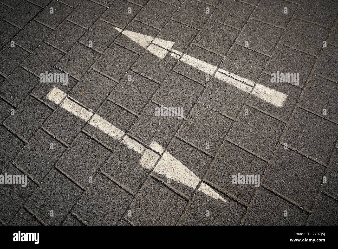 Directional arrows on a paved road Stock Photo - Alamy