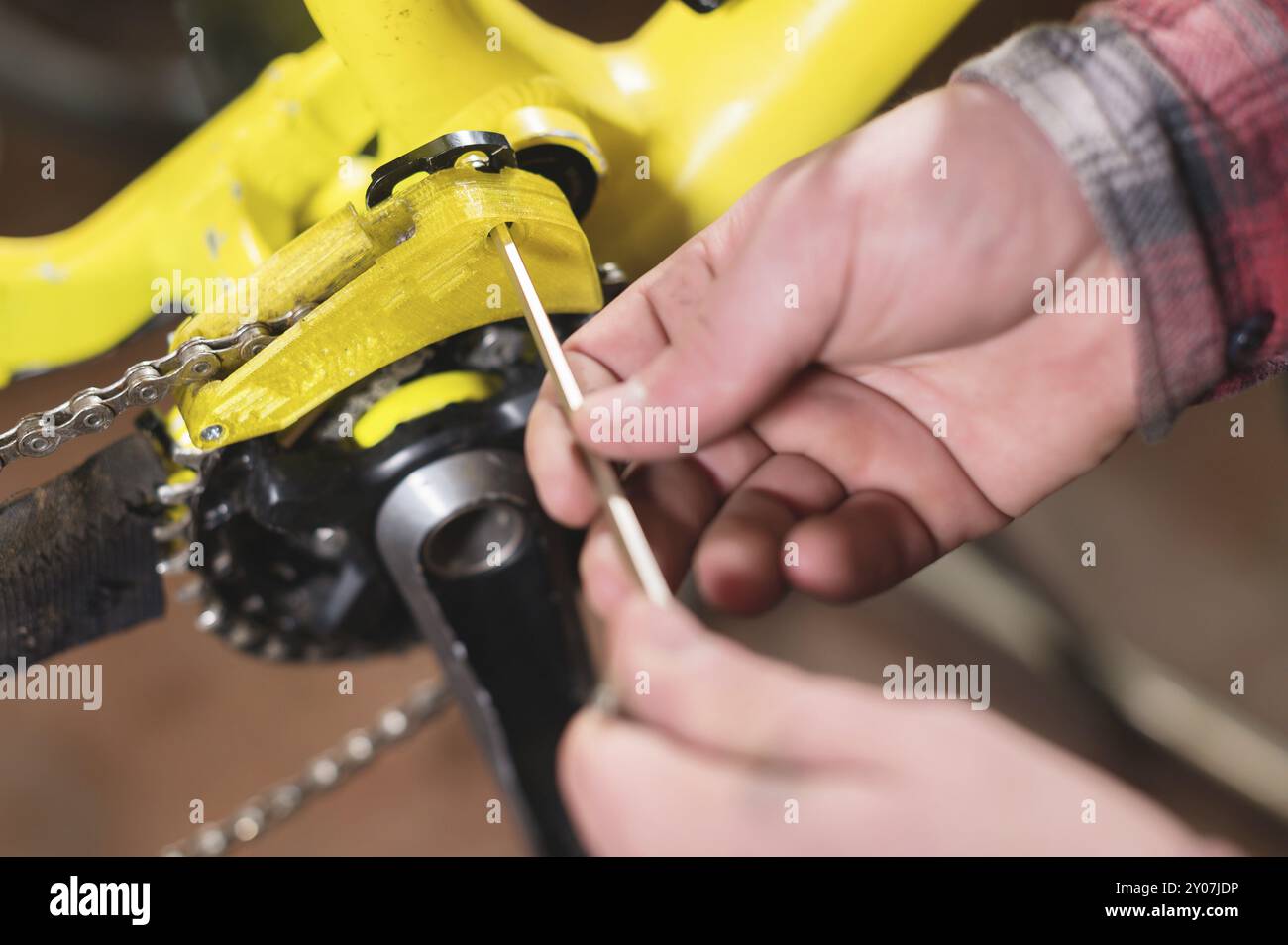Close-up maintenance of a mountain bike. Male hands adjust the chain ...