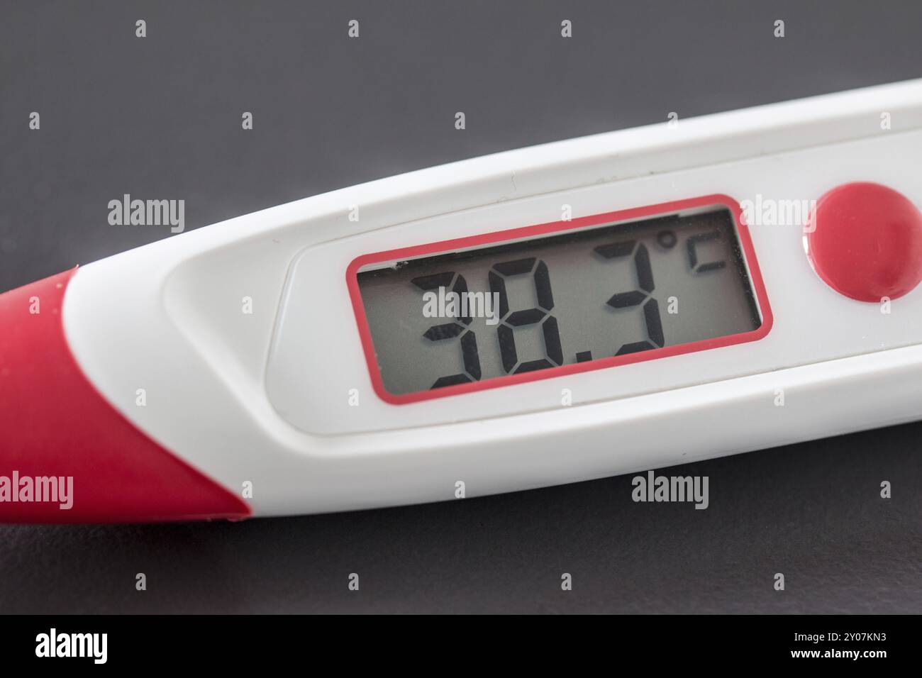 Red fever thermometer with digital display and 38 degrees Celsius lying ...
