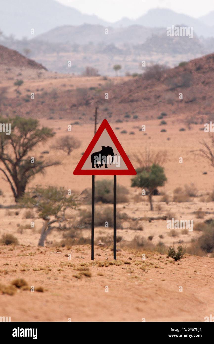 A sign on the side of a gravel road in Namibia warns of elephants, A ...