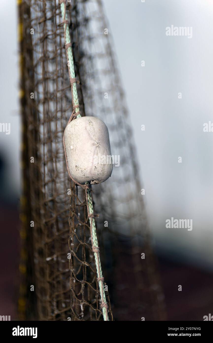 Small float on a fishing net Stock Photo - Alamy