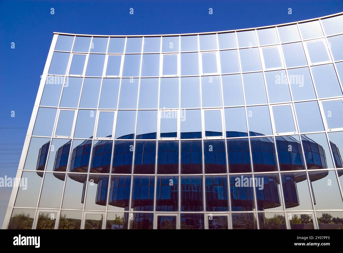 Reflections in the glass facade of an office building Stock Photo - Alamy