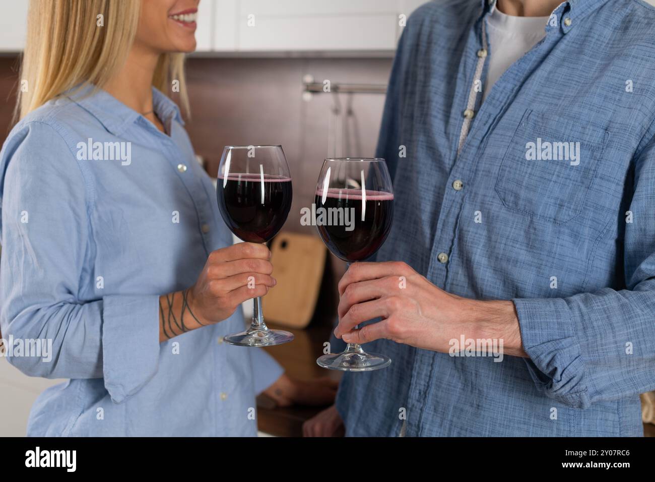 Close-up happy couple having fun and toasting standing on a kitchen ...