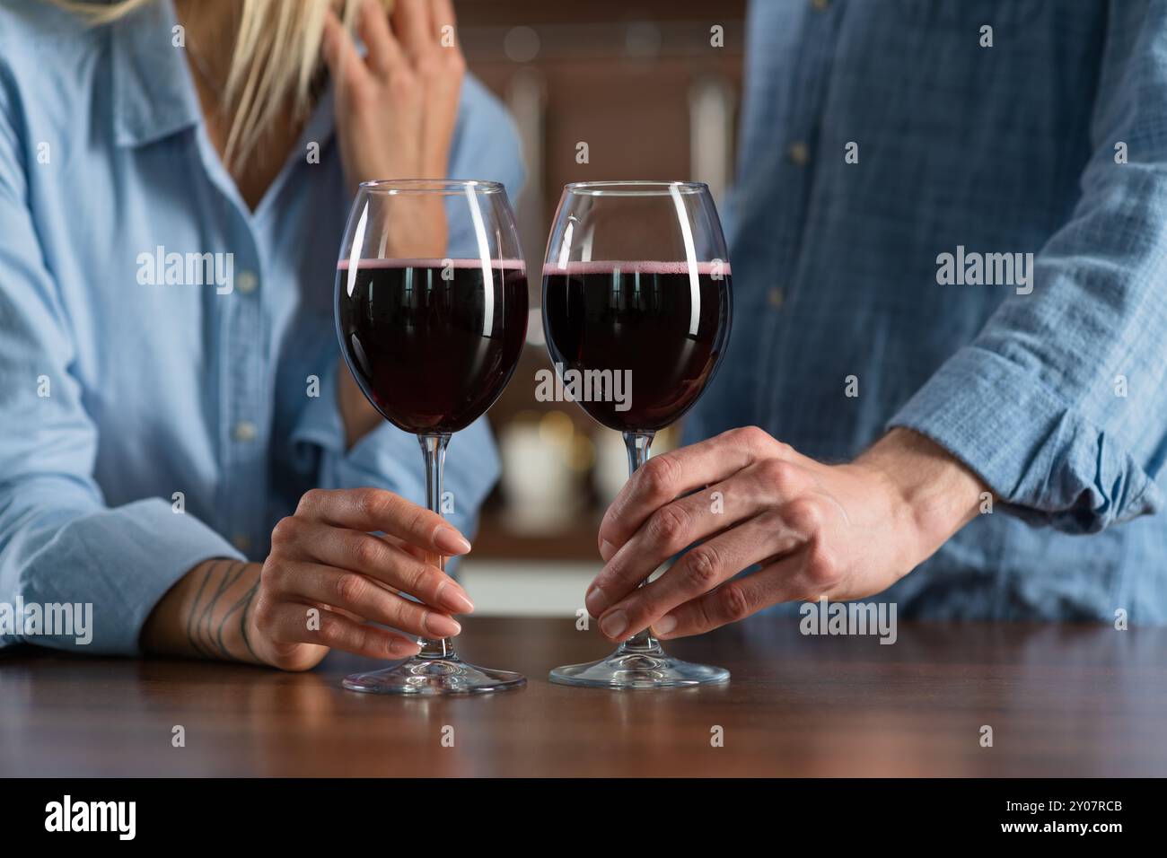 Close-up happy couple having fun and toasting standing on a kitchen ...