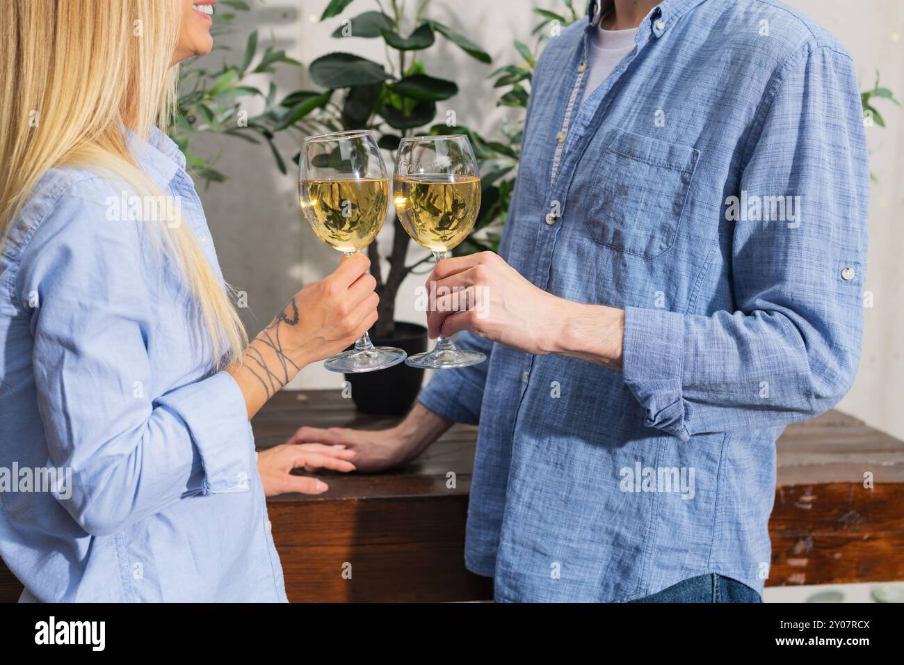 Happy couple toast and drinking white wine outside at farmhouse garden ...