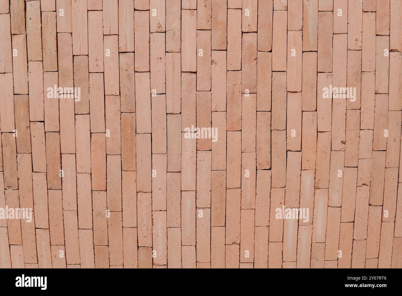 A brick wall with a pattern of squares. The wall is brown and has a ...