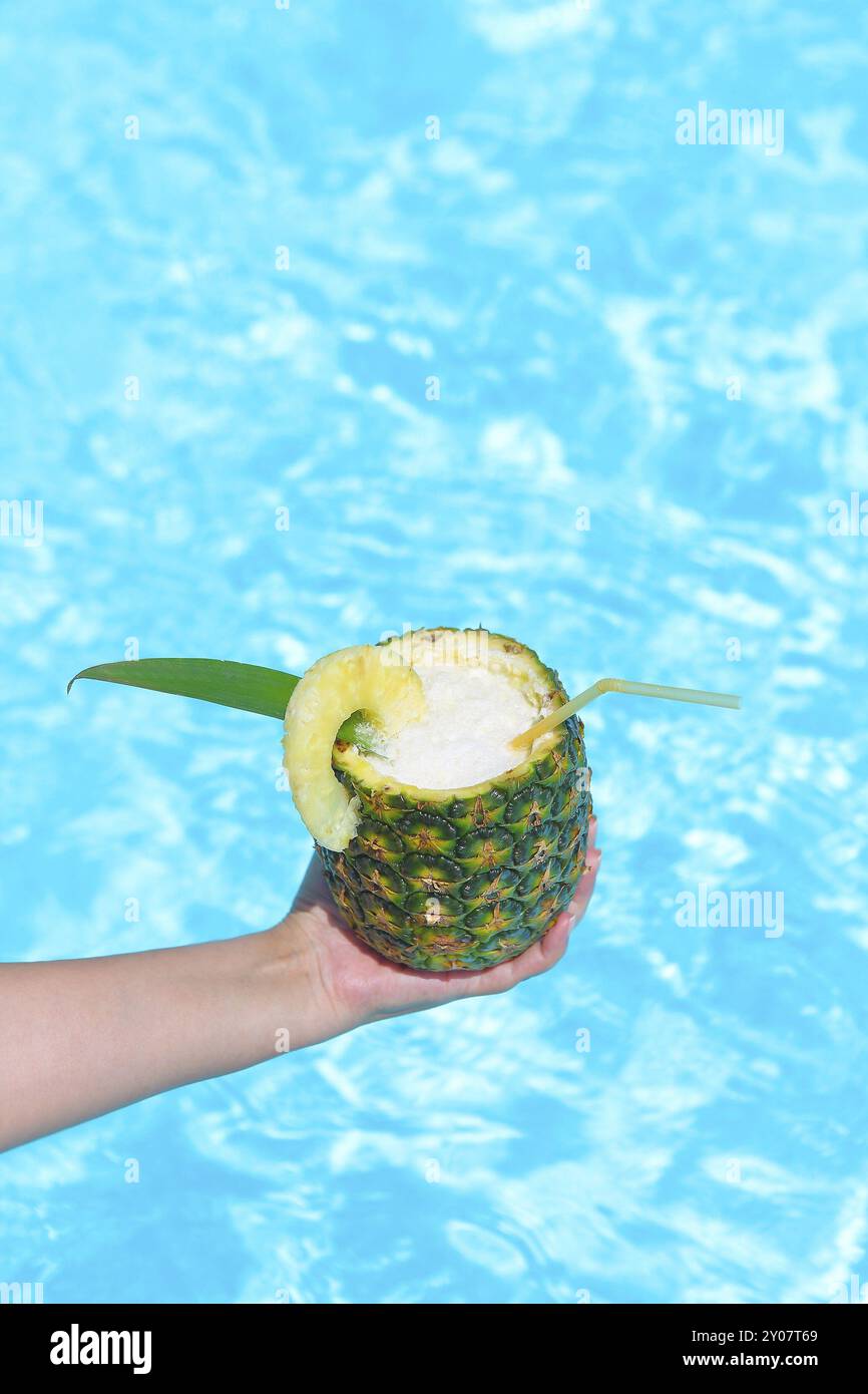 Hand with Pineapple exotic coctail near swimming pool Pina colada Stock ...
