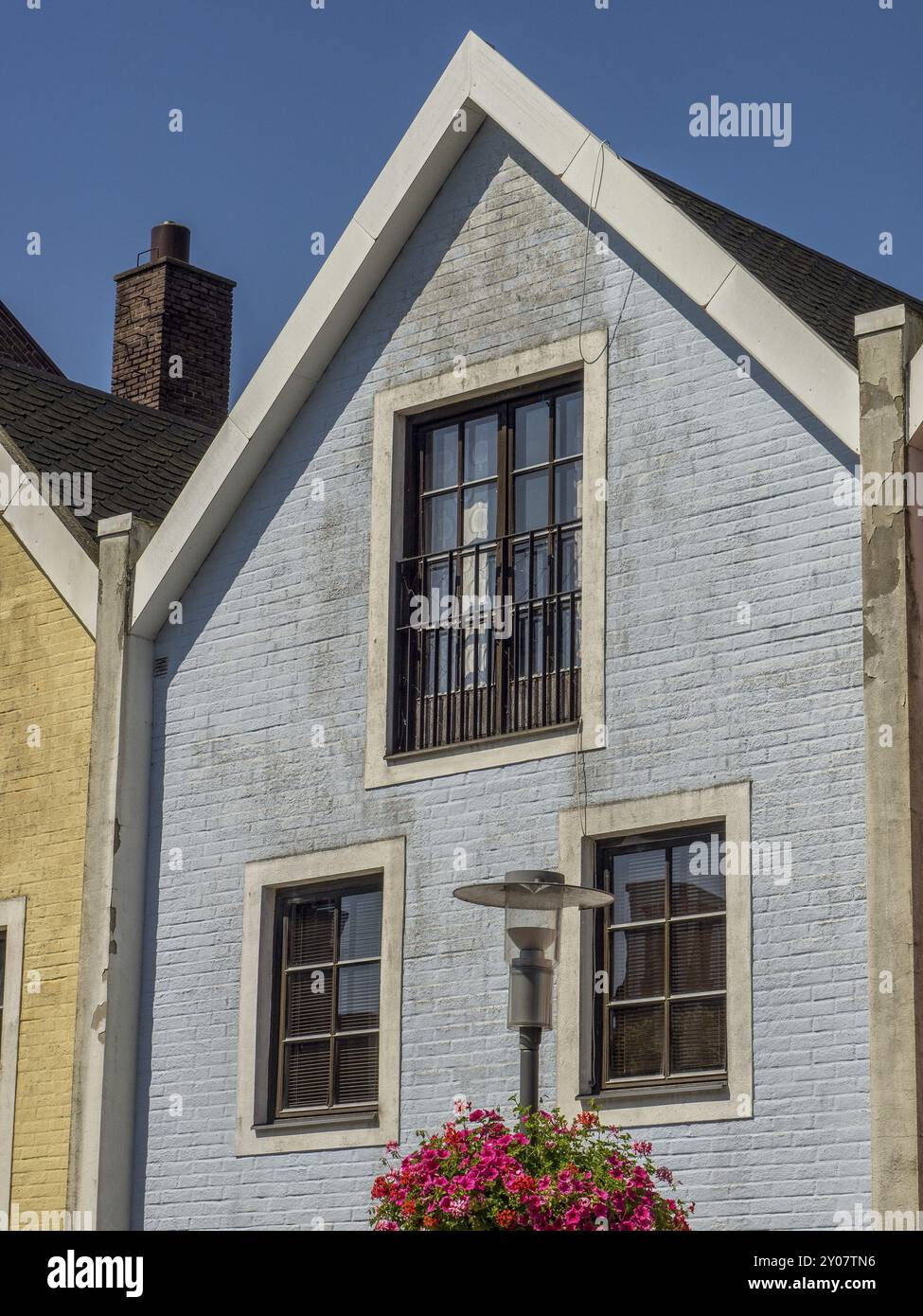 Facade of a blue house with windows and street lamp under a clear ...