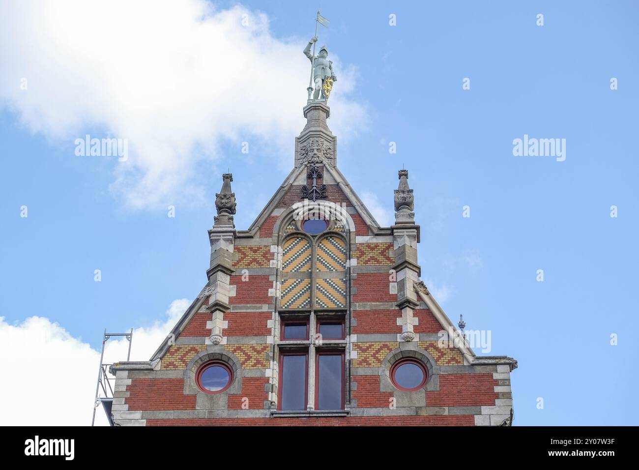 Historic building with a gable and a statue on the roof in front of a ...