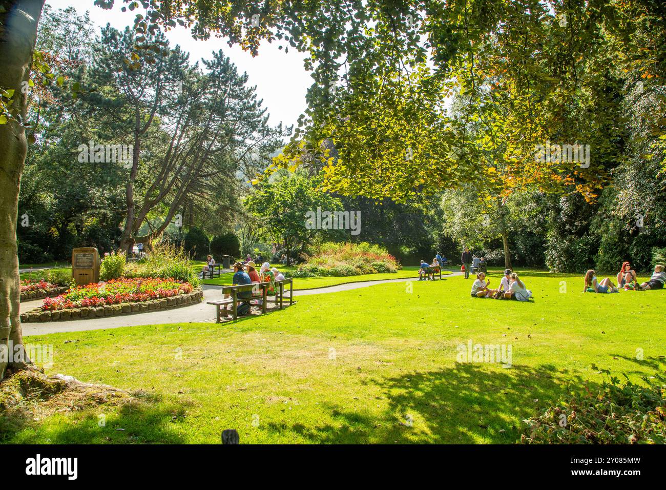 People enjoying the summer sunshine sunbathing in the park in the West ...