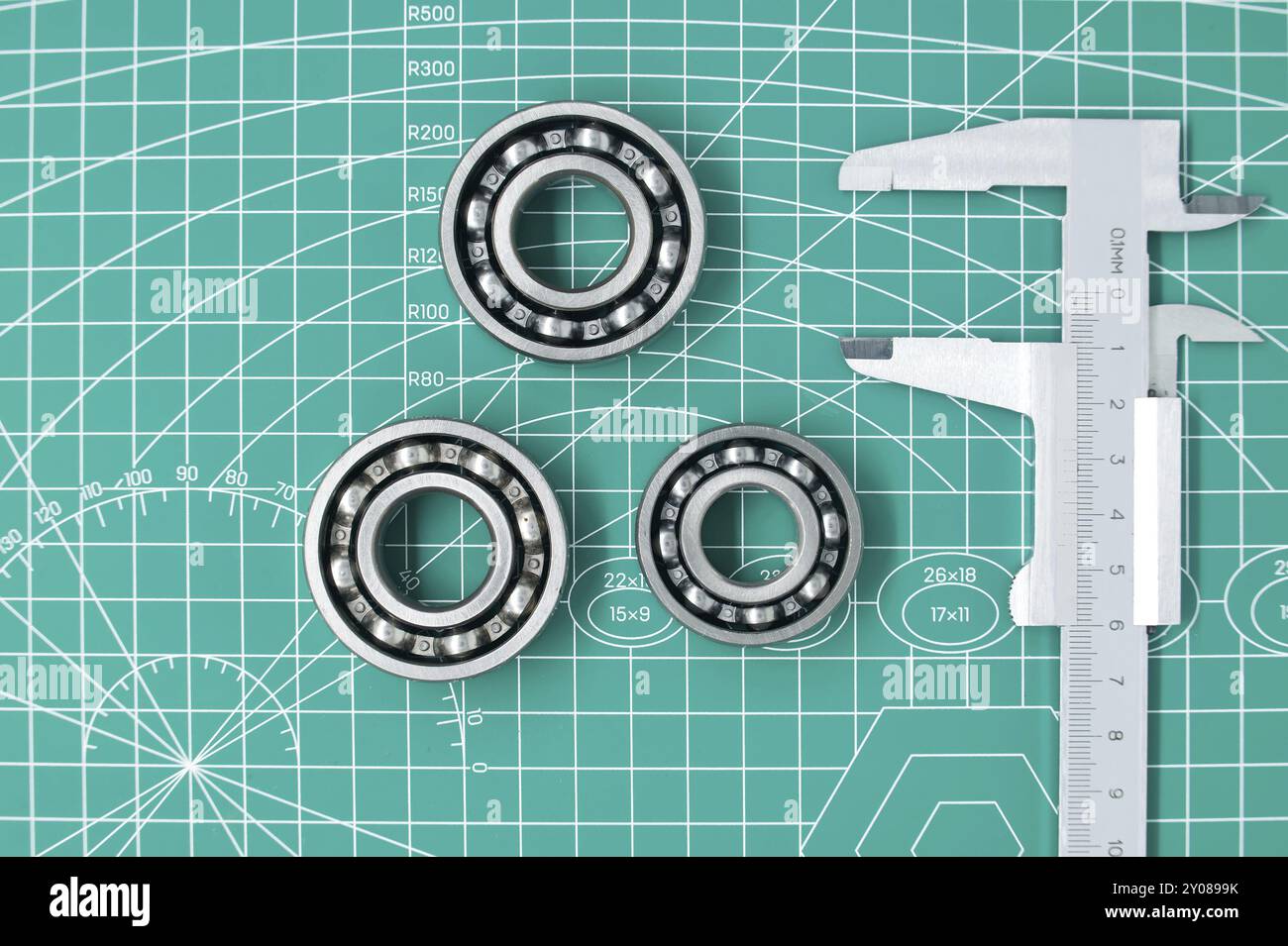 Measure caliper and roller bearings on green cutting mat with free copy ...