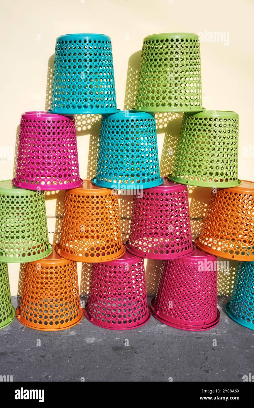 Plastic perforated baskets lined up against the wall Stock Photo - Alamy