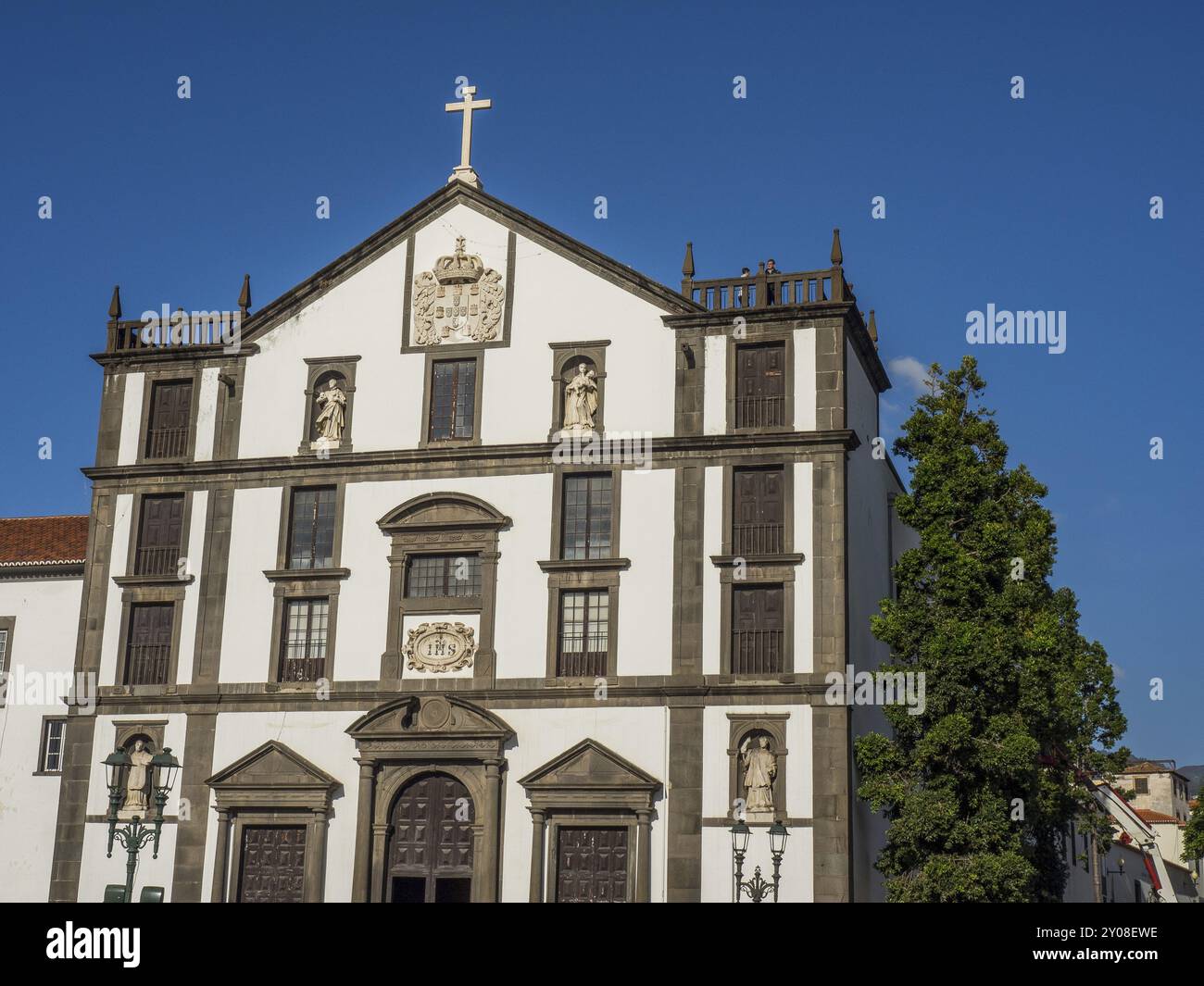 Church facade with windows and crosses under a clear blue sky, Funchal ...