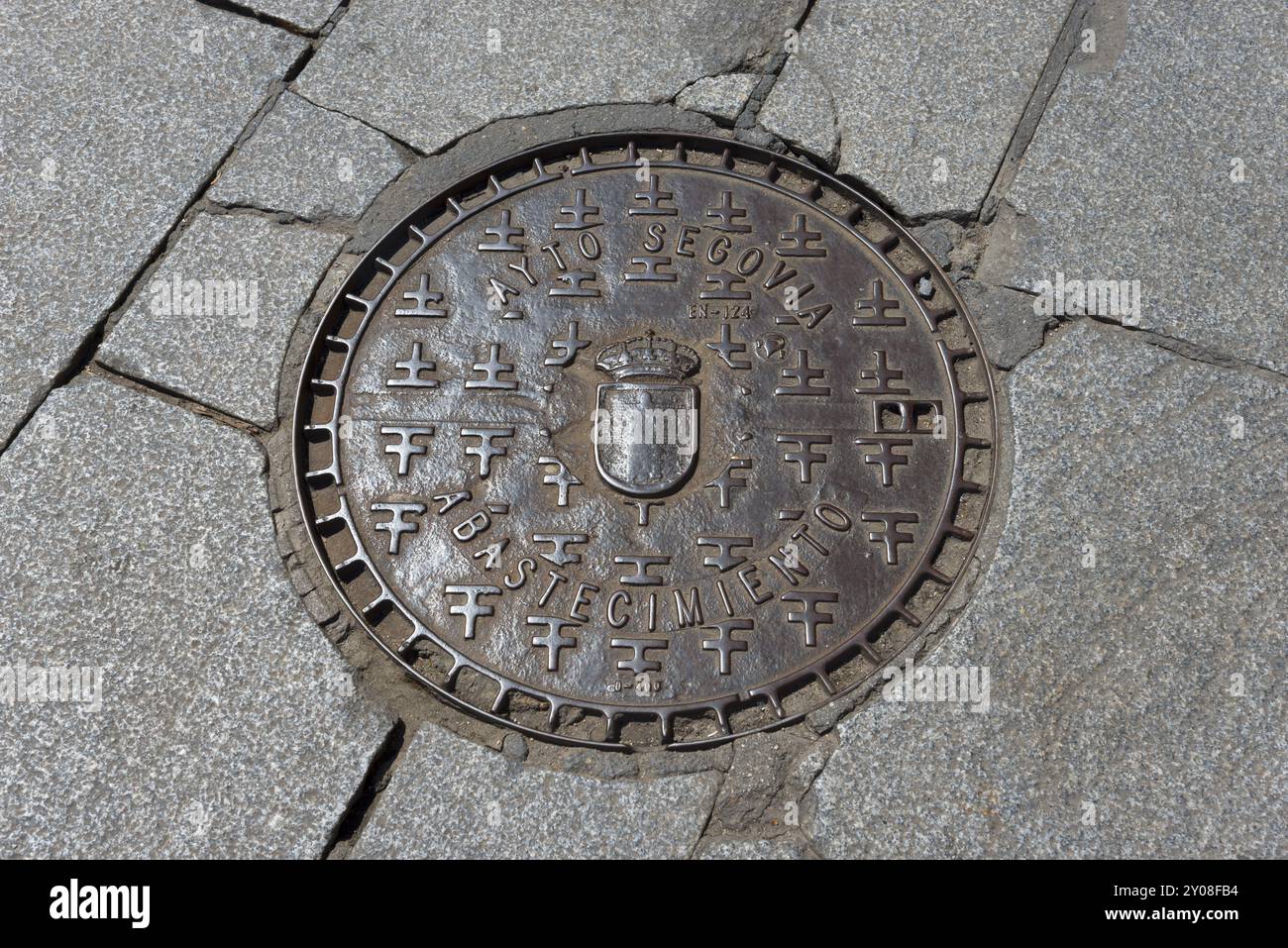 Manhole cover with the coat of arms and inscription of Segovia on a ...