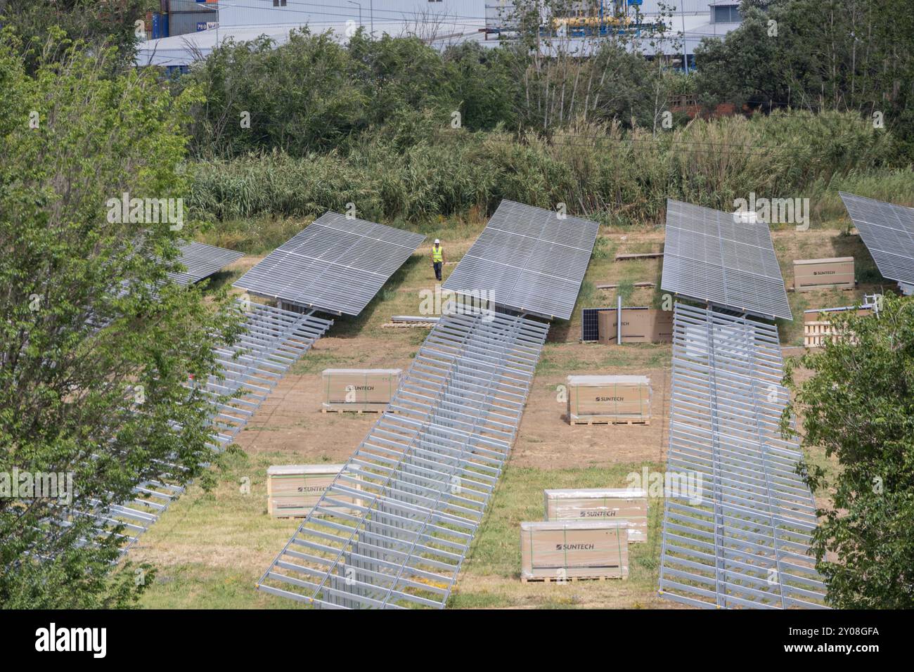 Worker walking in a solar farm during the installation of photovoltaic ...