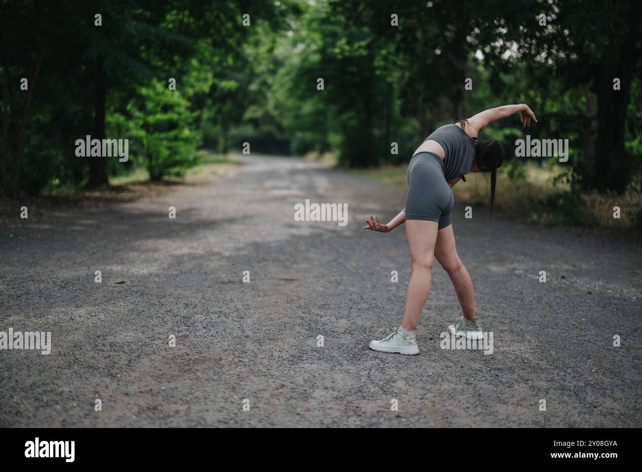 Girl gracefully dancing in a serene park setting, expressing joy and freedom amidst lush ...