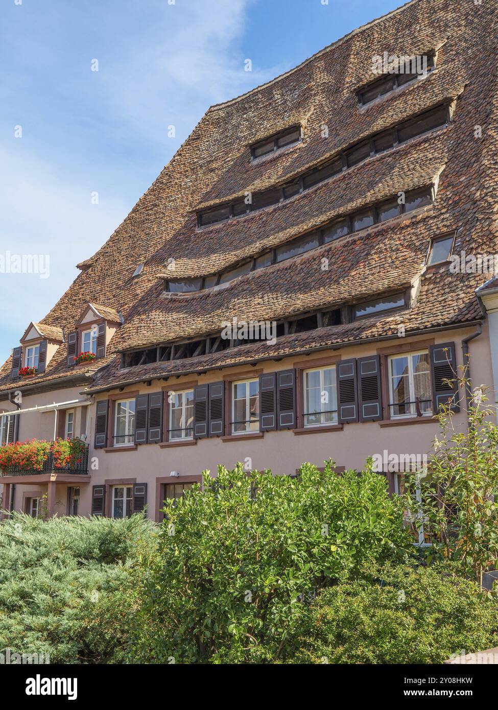 Characteristic old building with sloping tiled roof, shutters, balcony ...