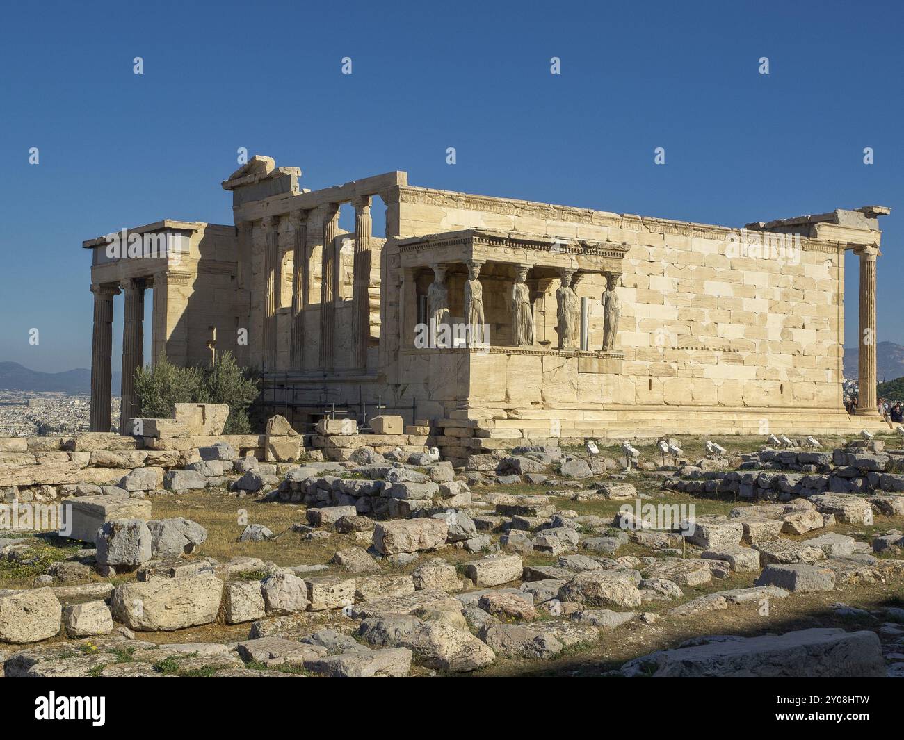 Ancient stone columns in a landscape of ruins under a clear blue sky, athens, greece Stock Photo ...