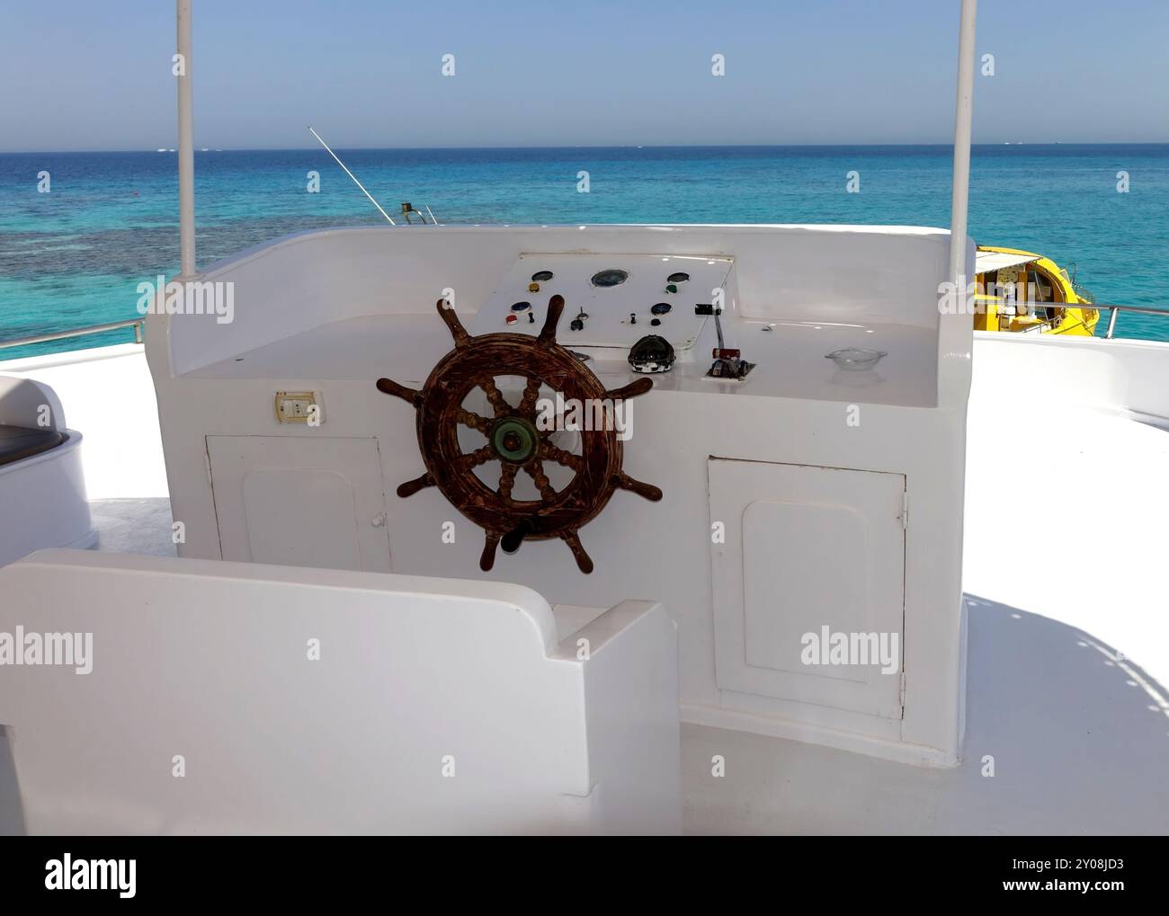 A captain confidently controls the yacht's helm while sailing the ...