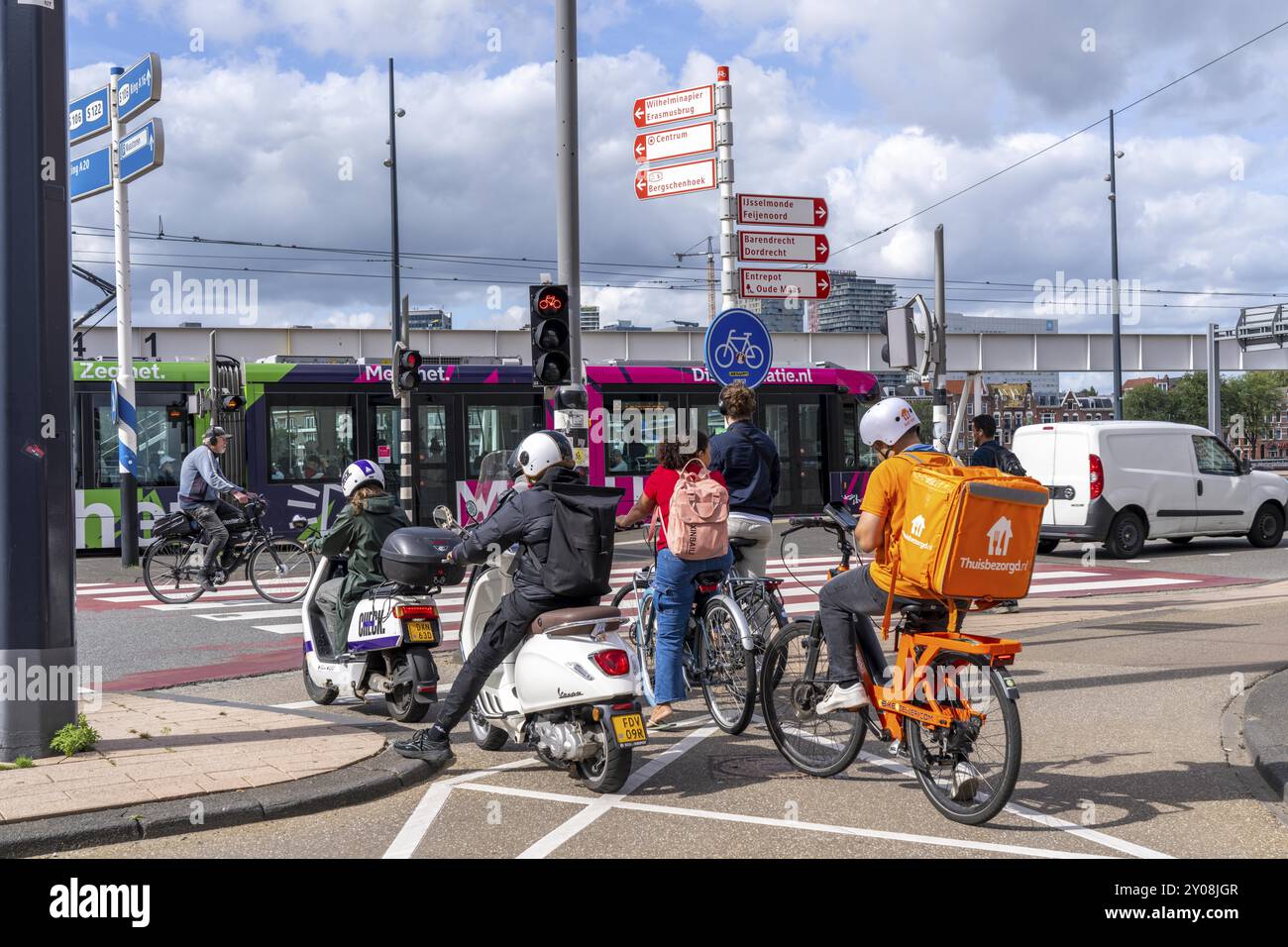 Cyclist, moped rider, waiting at a red traffic light, Feijenoord, in ...
