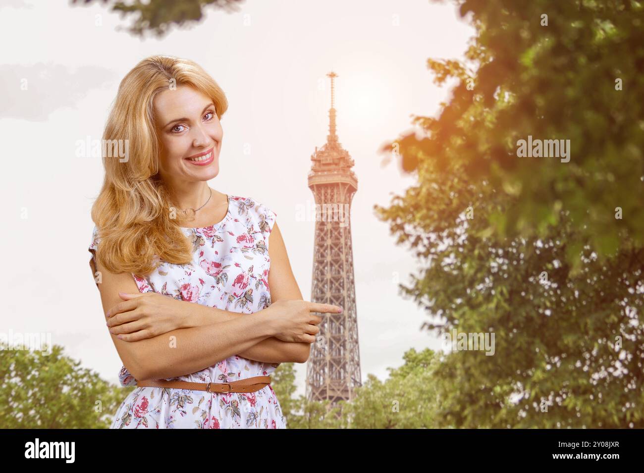 Portrait of happy cheerful blonde woman standing outdoors with folded ...