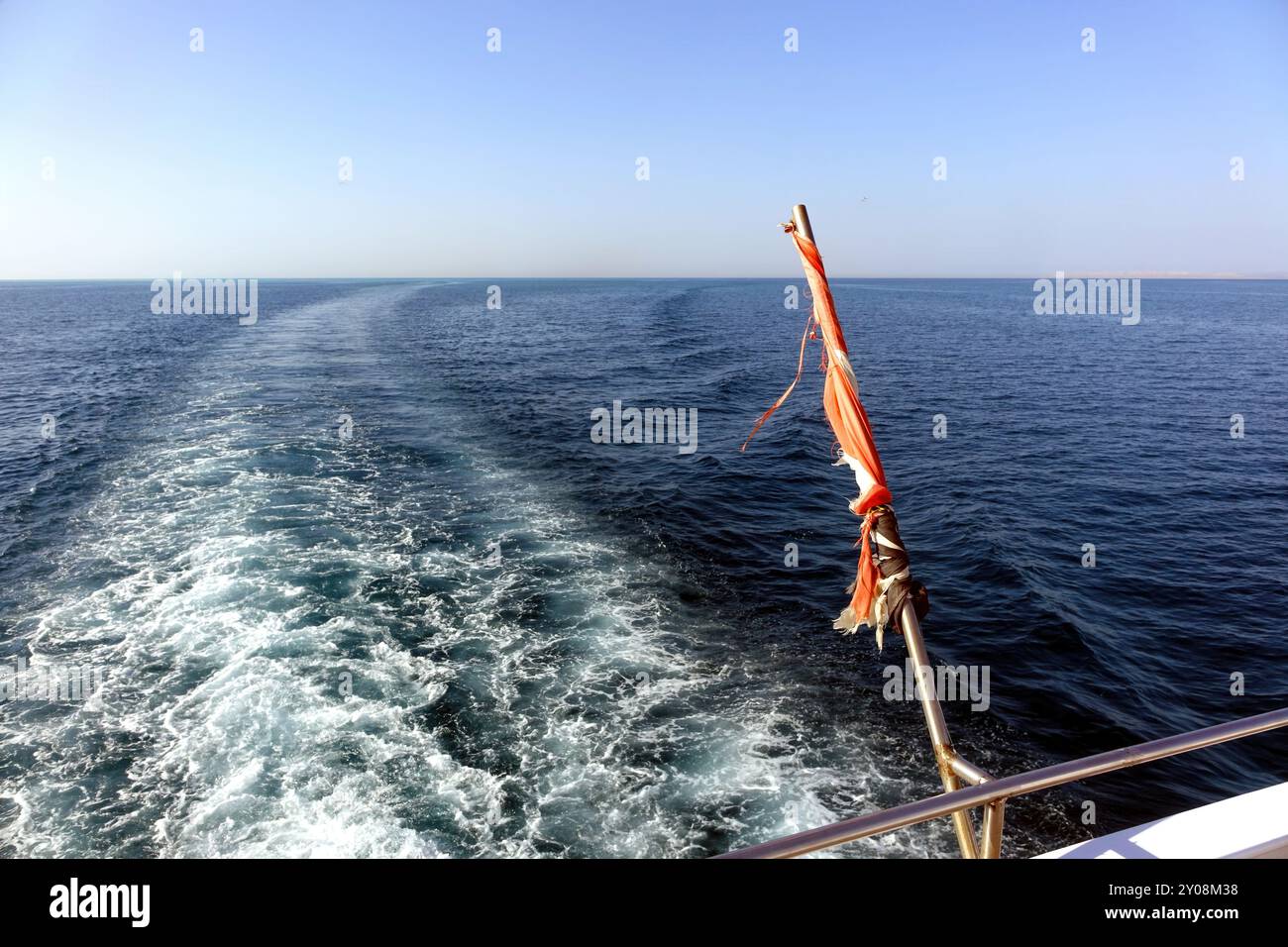 Gentle waves form behind a yacht gliding through the tranquil waters of ...