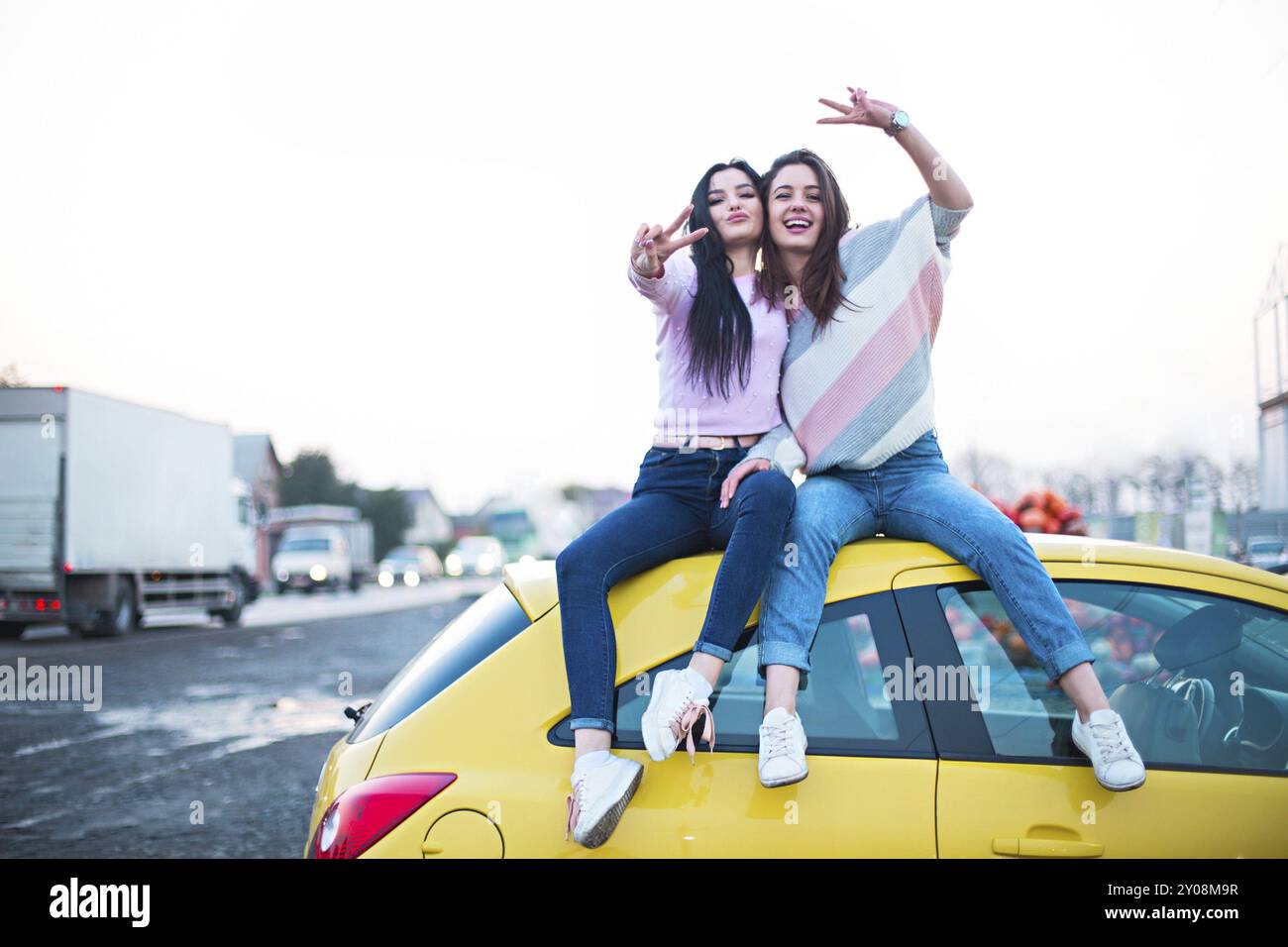 Best female friends cheering by car road trip at sunset. Happy people ...