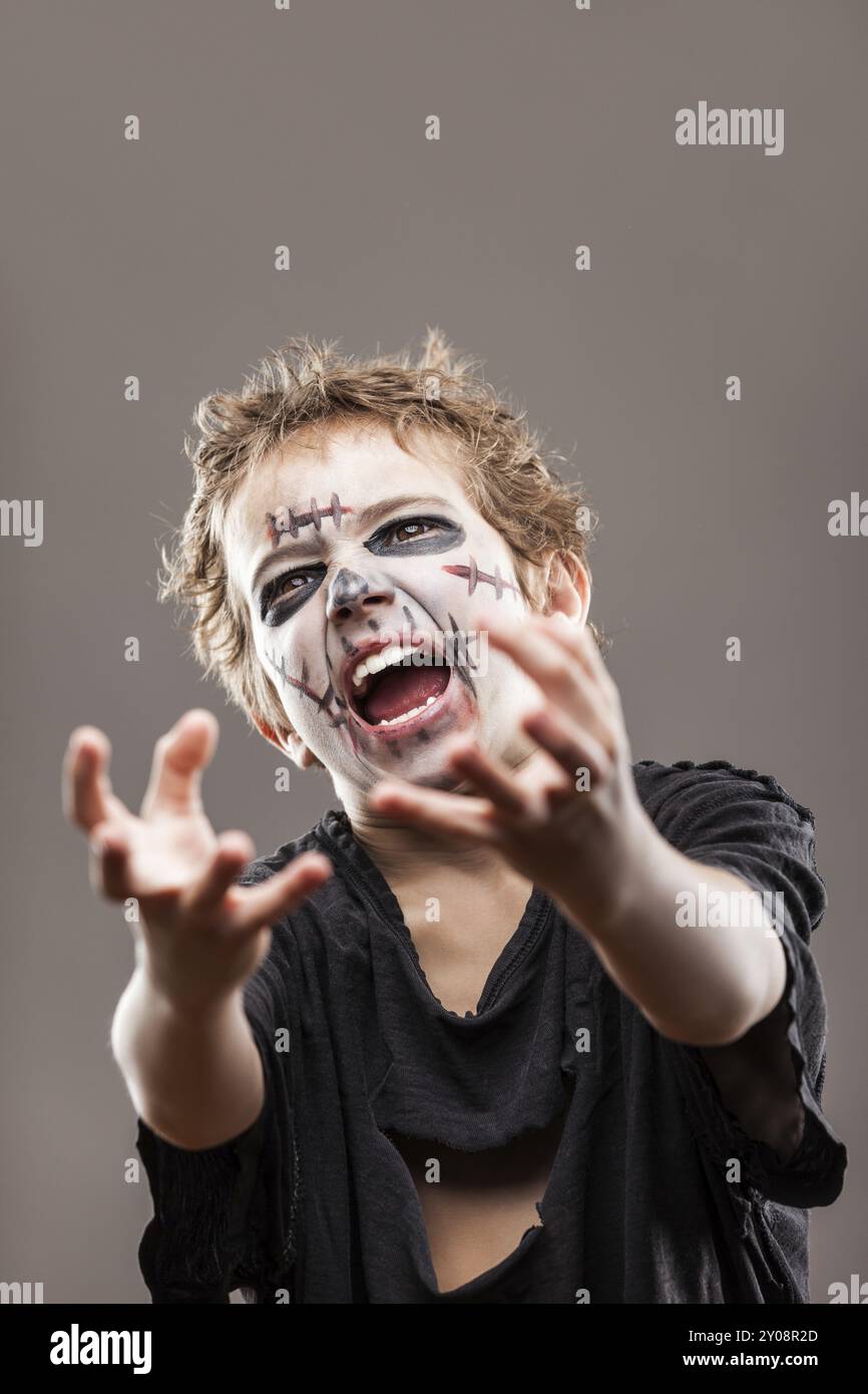 Halloween or horror concept, screaming walking dead zombie child boy ...
