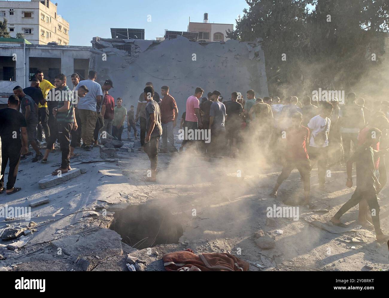 Palestinians inspect a school for victims, which was sheltering ...